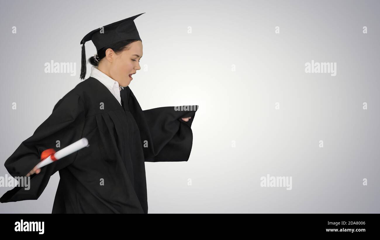 Happy female student in graduation robe walking and cheering wit Stock ...