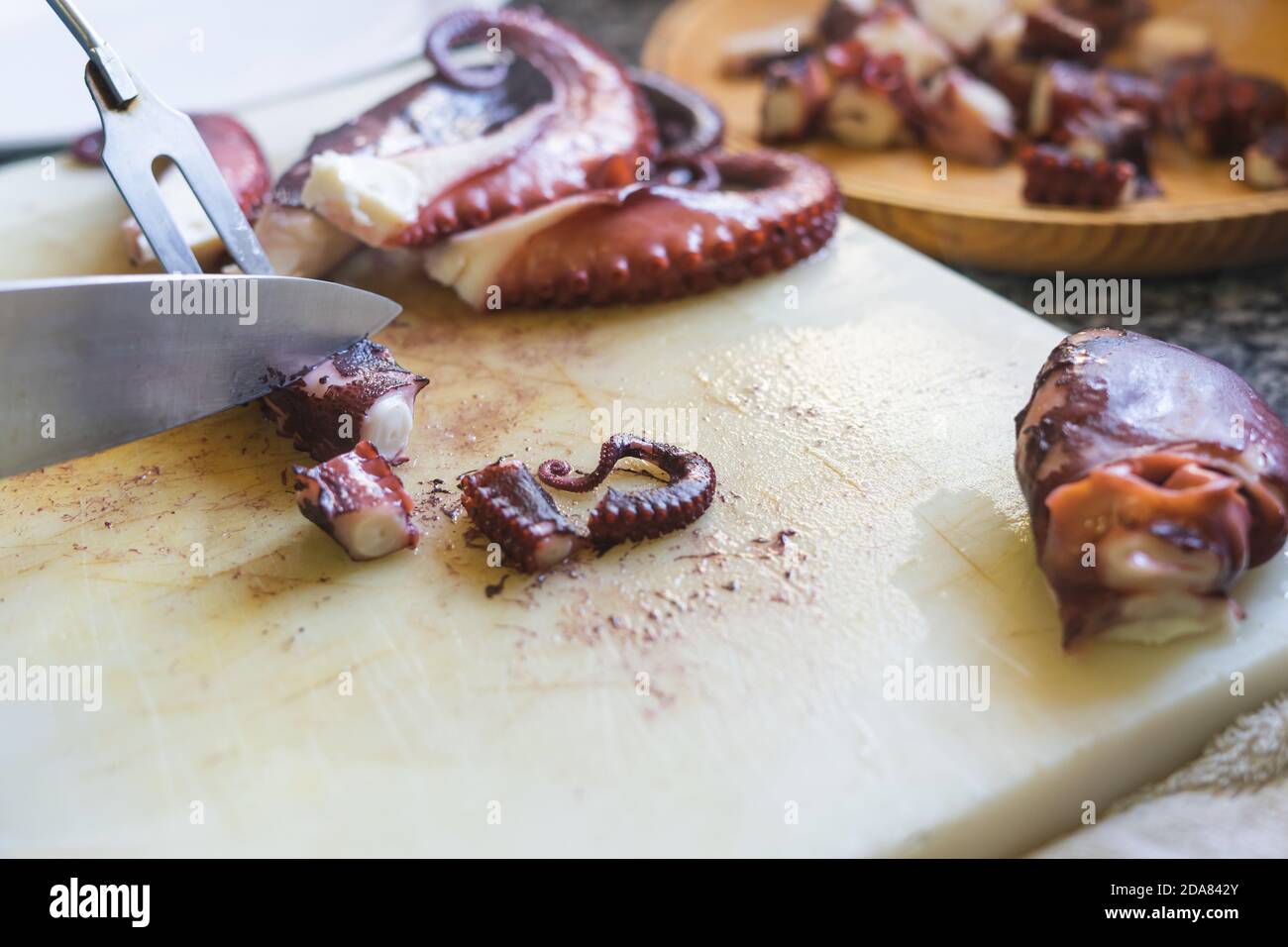 Cutting octopus on kitchen board Stock Photo - Alamy