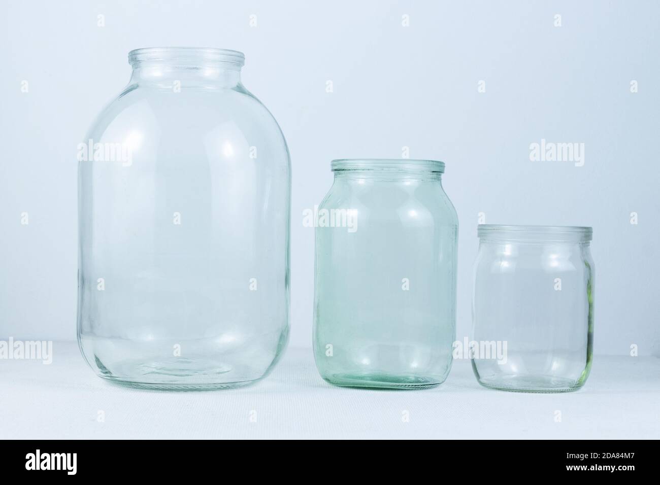 three empty glass jars of different sizes on a white background Stock ...