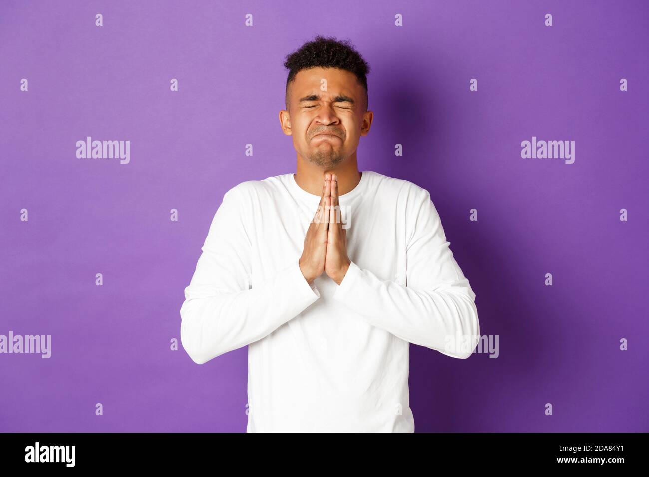 Image of desperate african-american guy pleading to God, holding hands ...