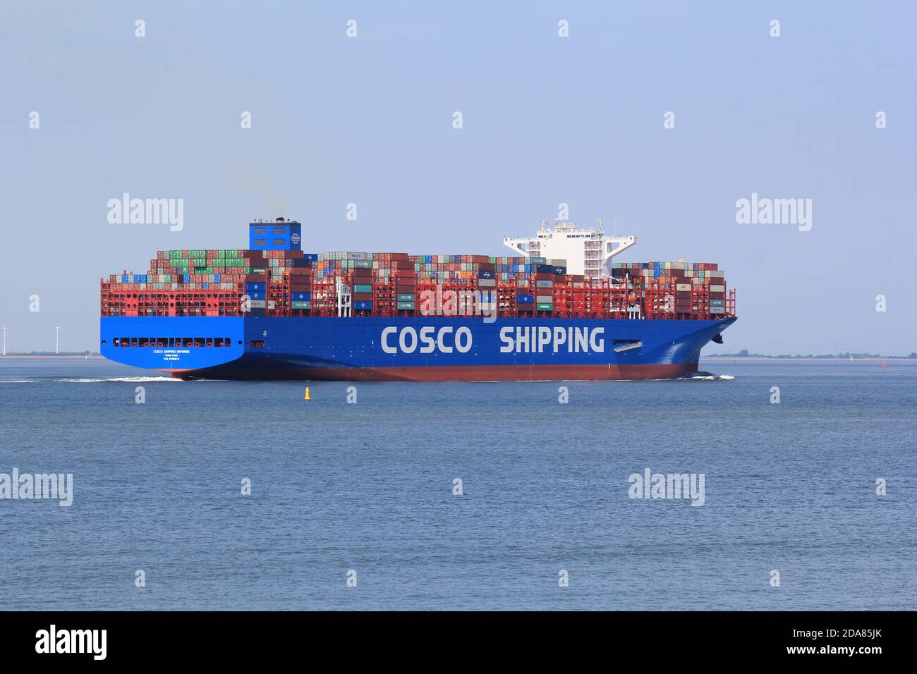 a big blue container ship sails through the westerschelde sea in summer ...