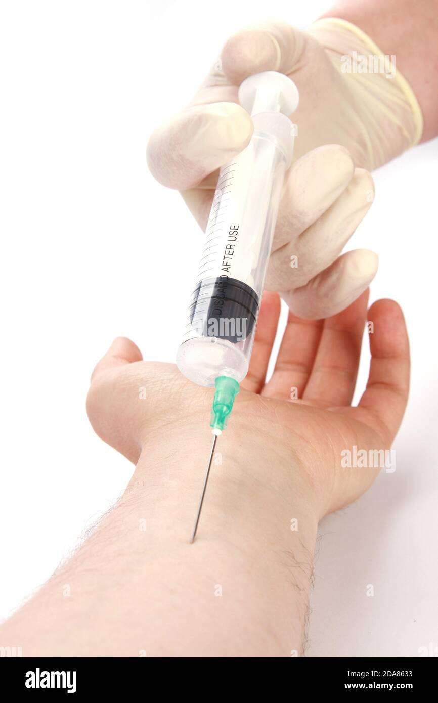 Vertical shot of a doctors hand injecting a syringe into a patients arm ...