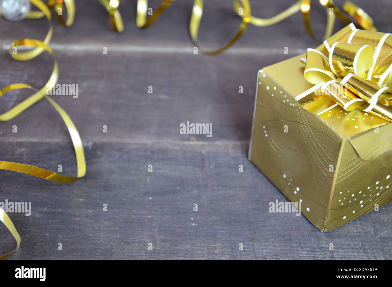 with gold ribbon and bow for a birthday or holiday on a brown wooden ...