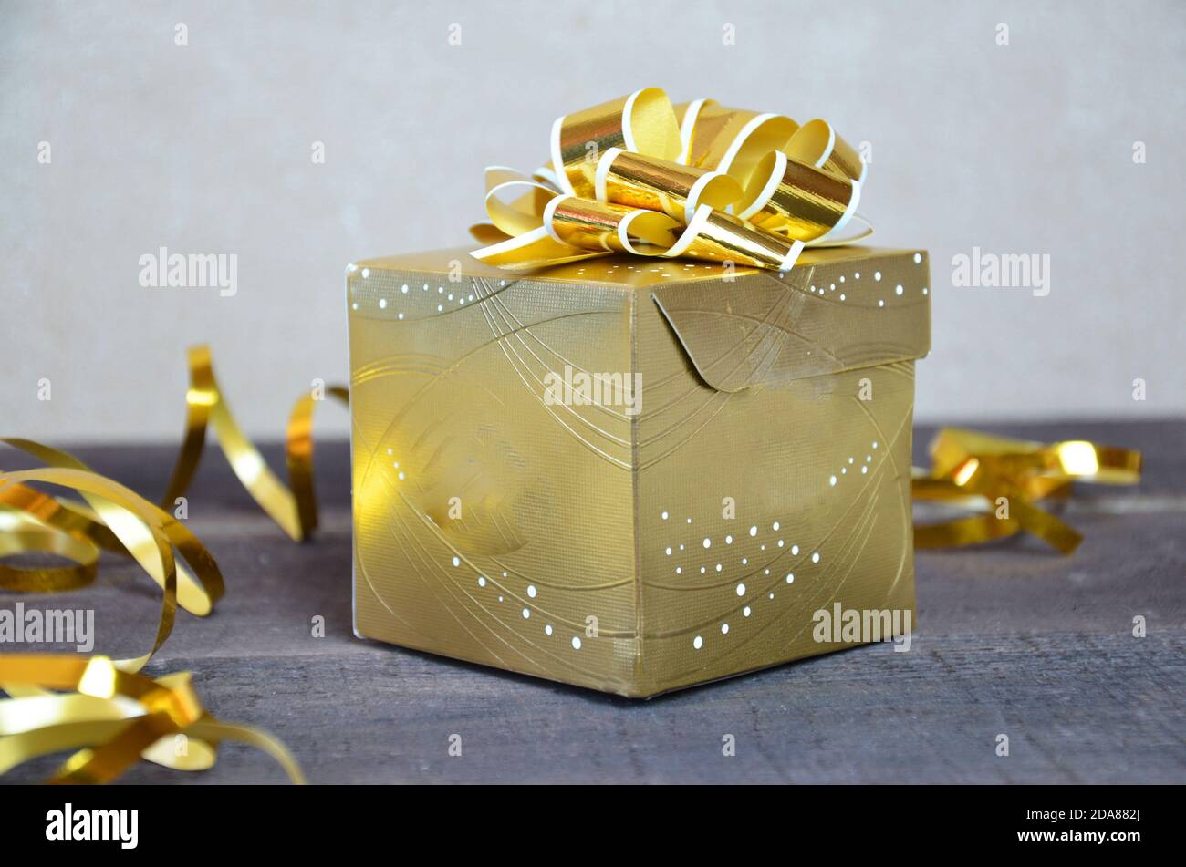 with gold ribbon and bow for a birthday or holiday on a brown wooden ...