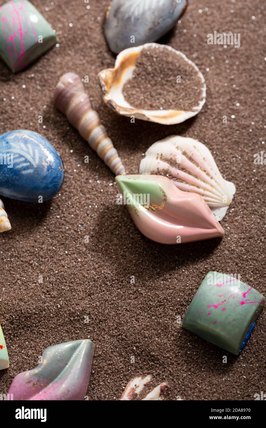 Chocolate candies and sea shells on sand Stock Photo - Alamy