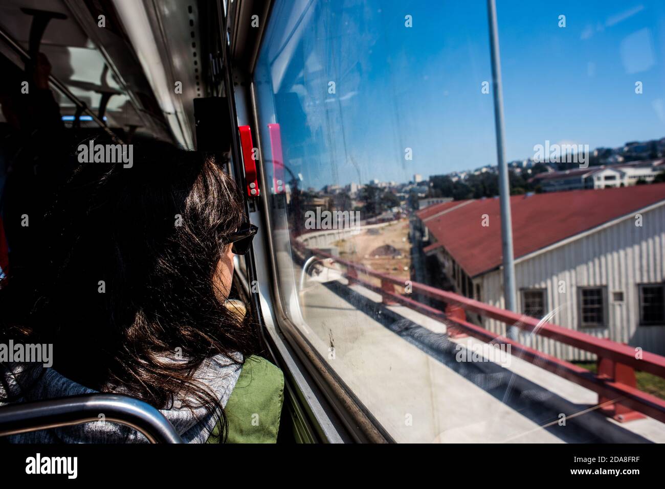 Girl looking out of the bus window Stock Photo - Alamy