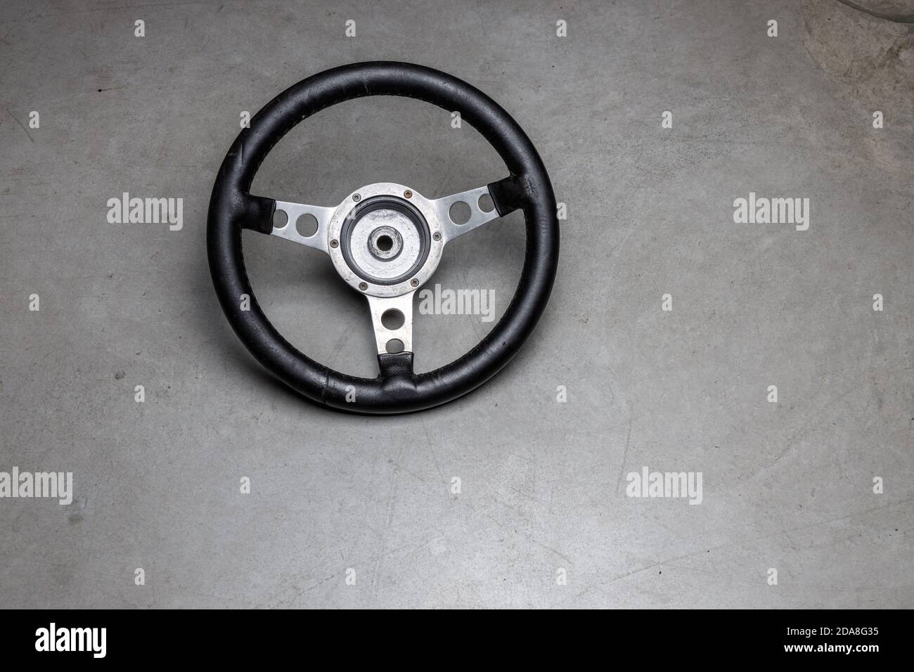 small racing steering wheel with black leather made of aluminum on a ...