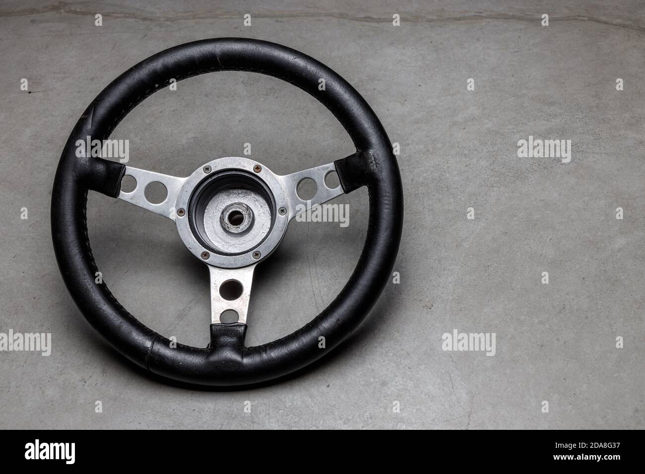 small racing steering wheel with black leather made of aluminum on a ...