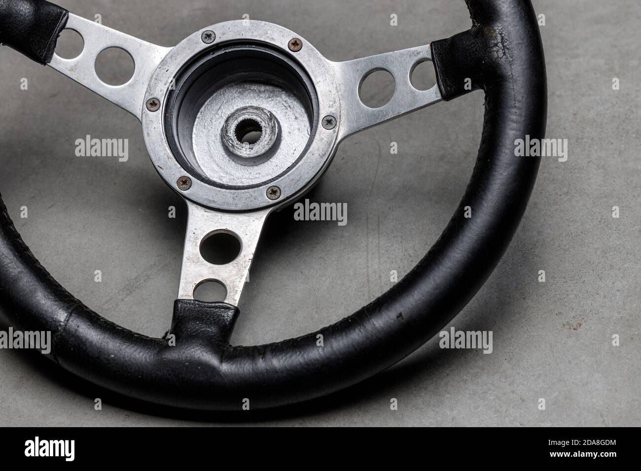 small racing steering wheel with black leather made of aluminum on a ...