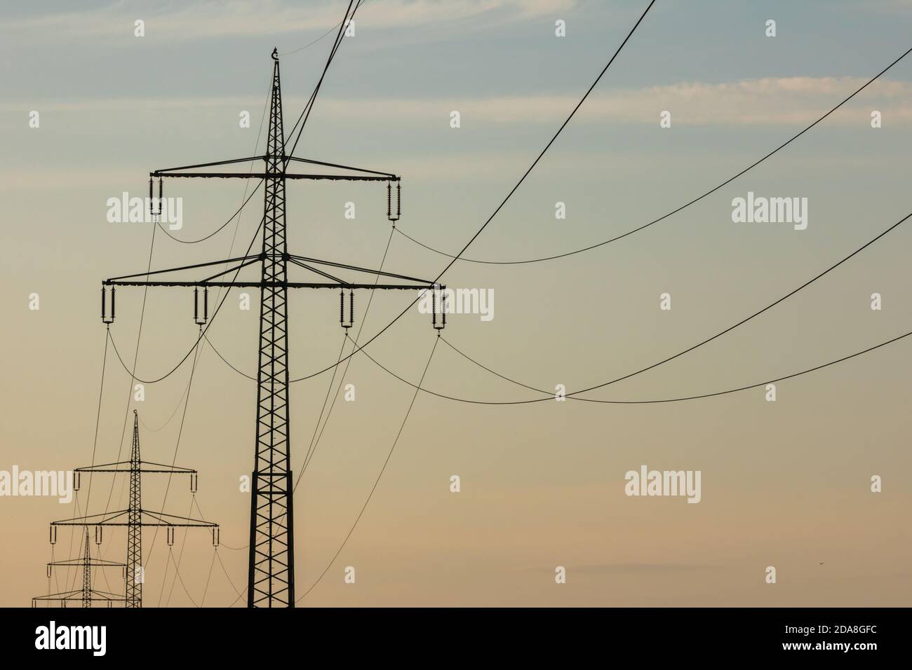 Power poles with power lines at sunset, light gradient from yellow to ...