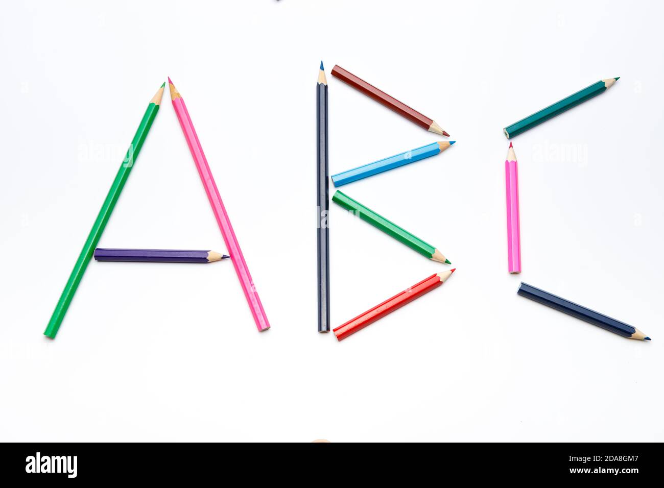 Simple letters a, b and c made of small color pencils on white uniform ...