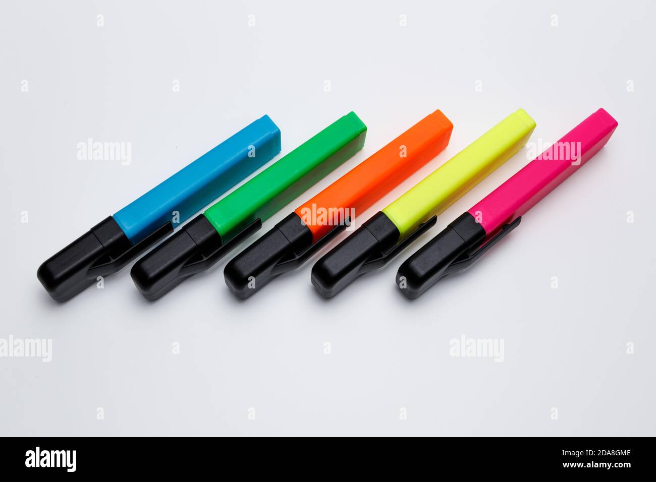 Highlighter pens of different colors with attached cap in a row on ...