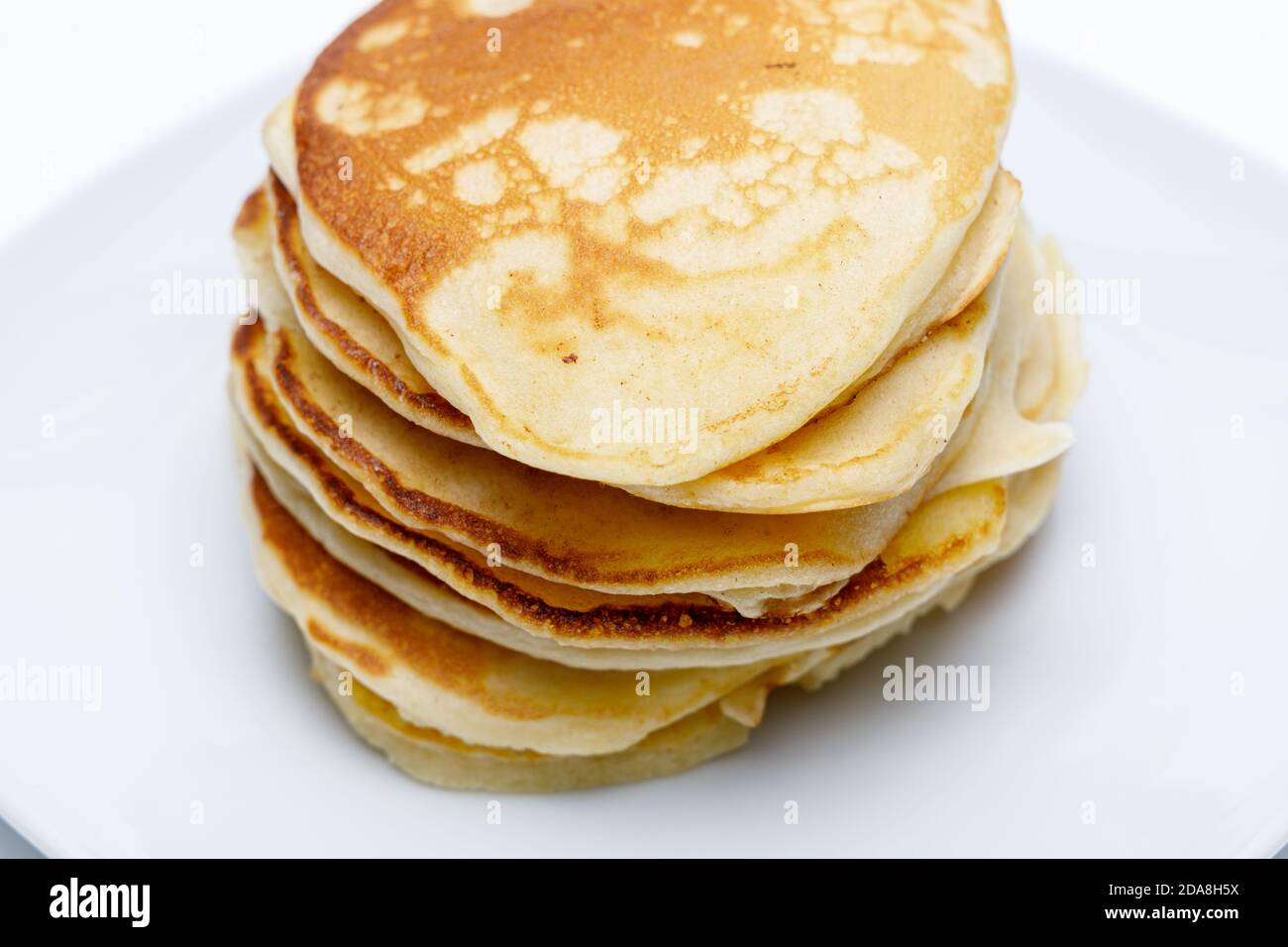 Top view, a pile of pancake on a white ceramic plate on white uniform ...