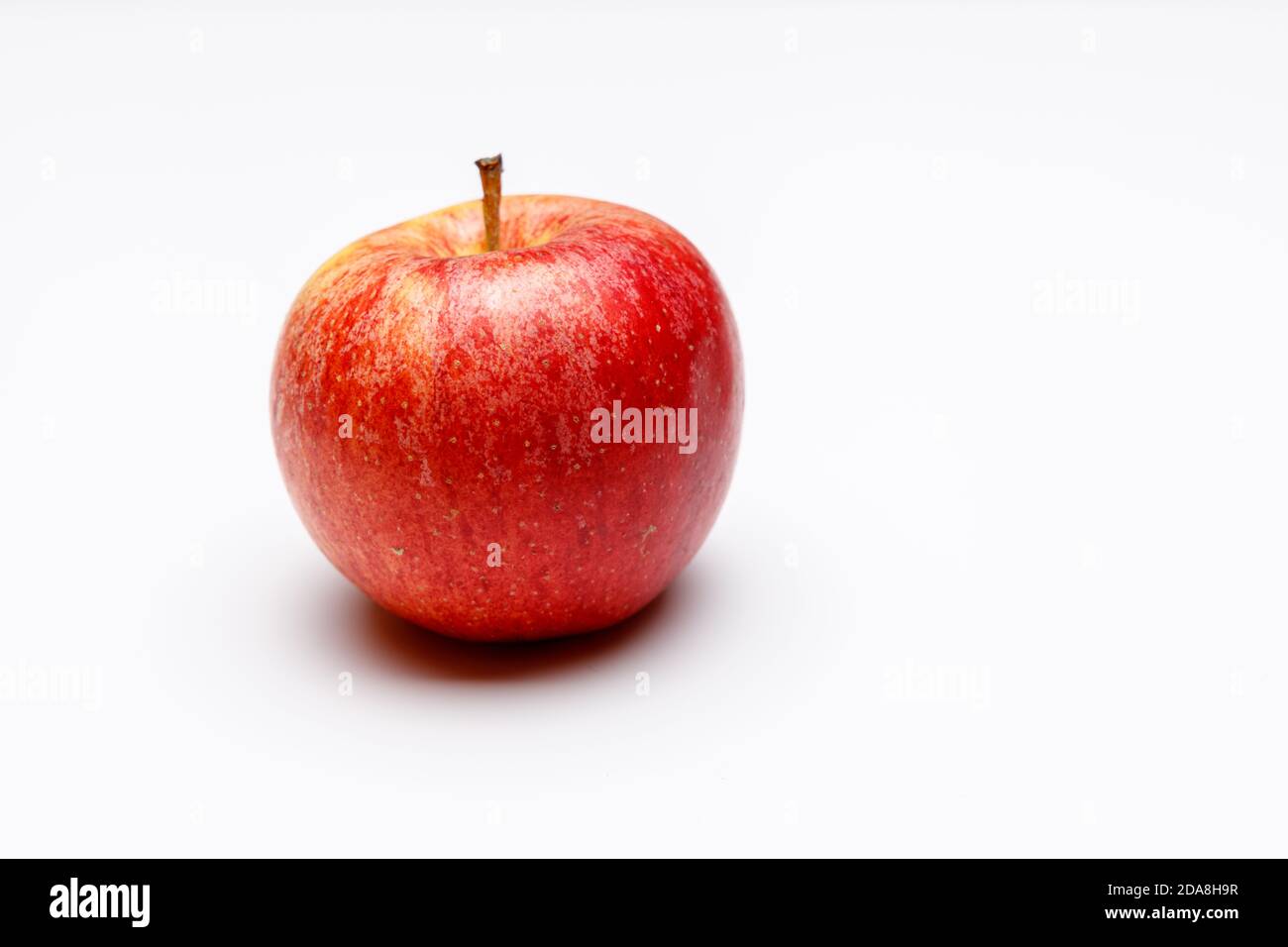 Single red apple on white isolated background with small yellow spots ...