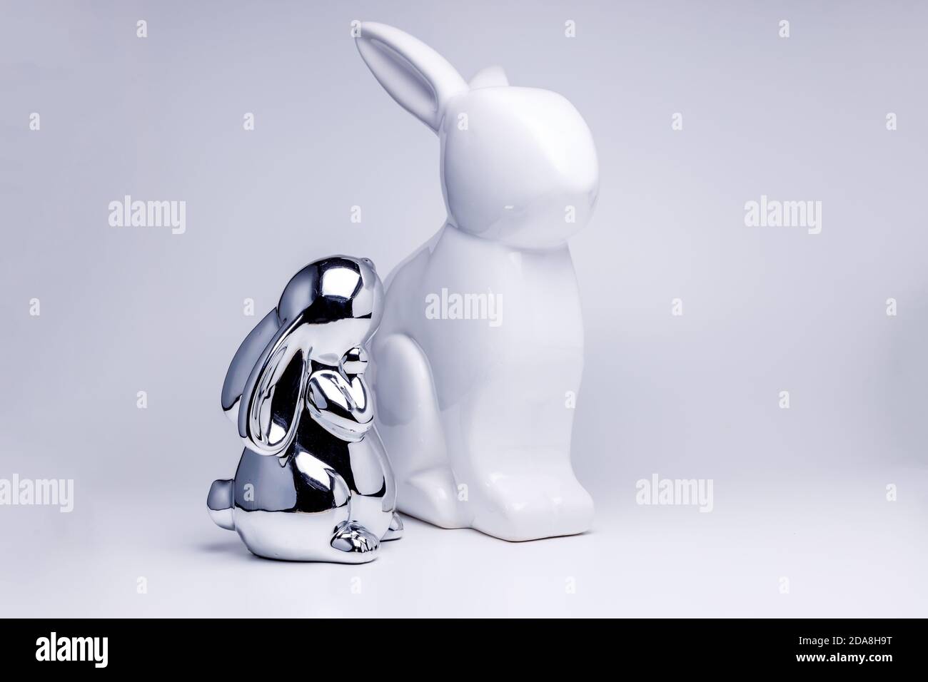 Abstract easter bunny figures on white uniform background, one bunny is ...