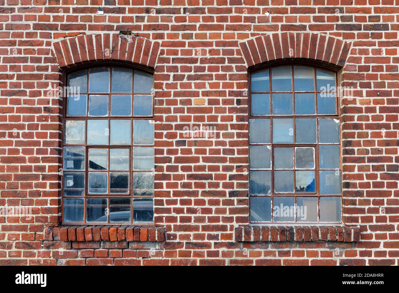 Two industrial looking windows with broken pieces of glas, the window ...