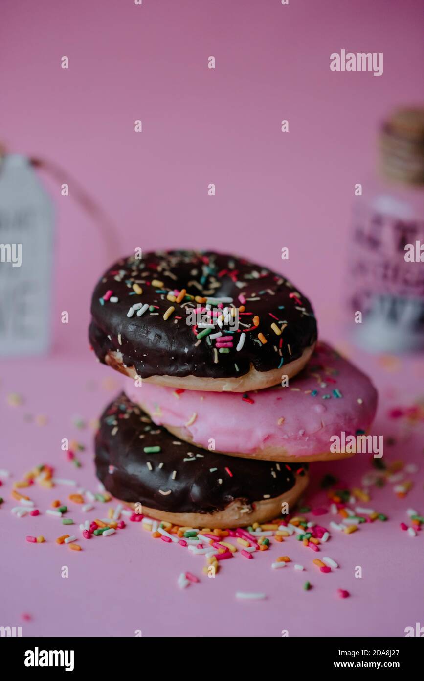 Closeup shot of assorted chocolate donuts with sprinkles and love notes ...