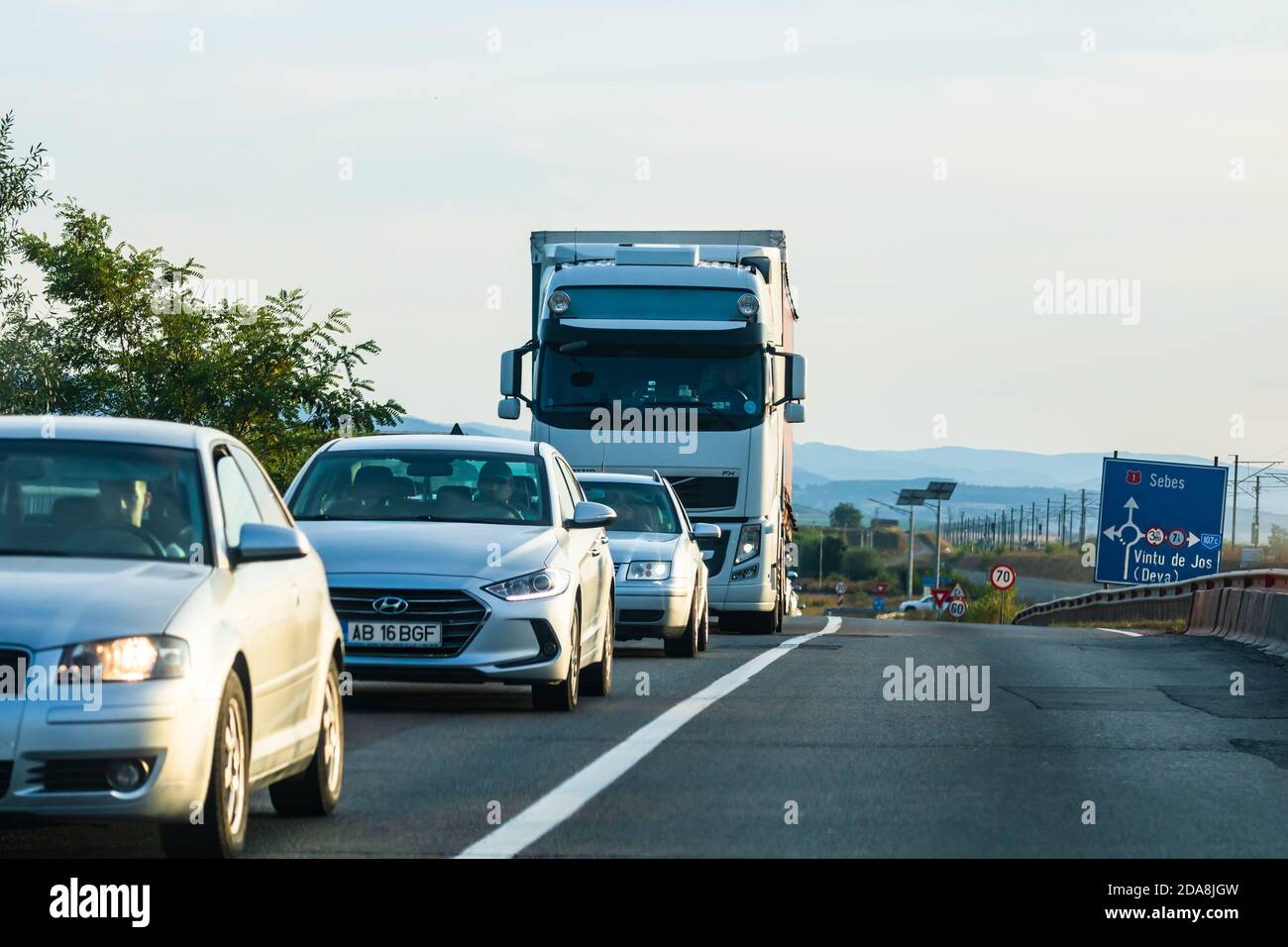 Traveling cars in motion on asphalt road, front view of cars in row on ...