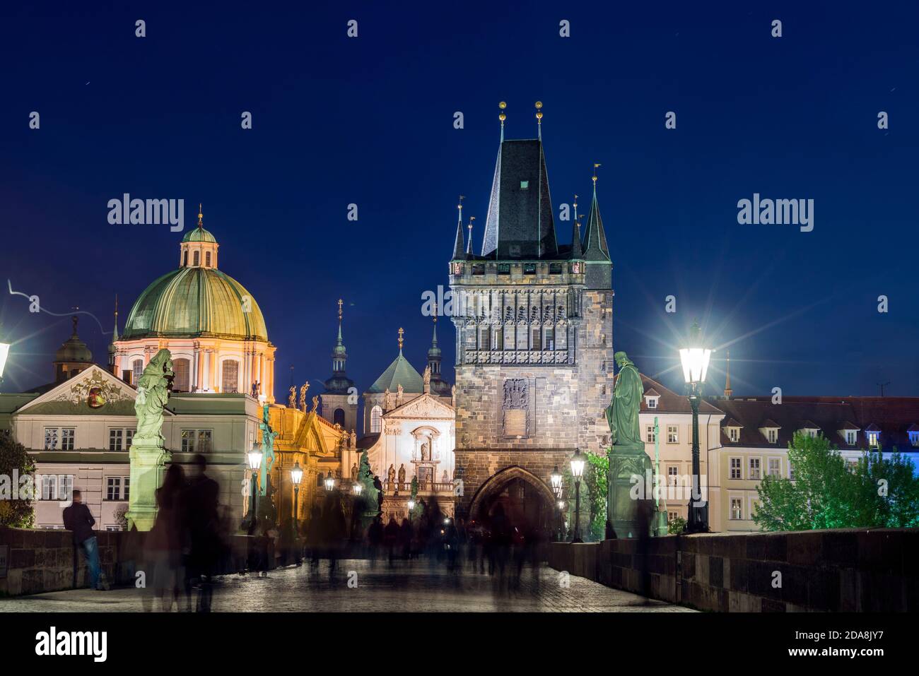 night view of charles bridge crowded with tourists, old town bridge tower and the dome of ...