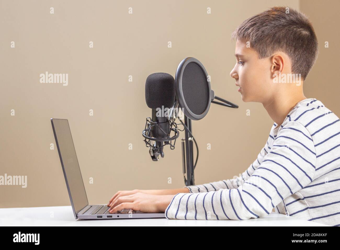 Kid with laptop computer talking into microphone. Techology, online ...