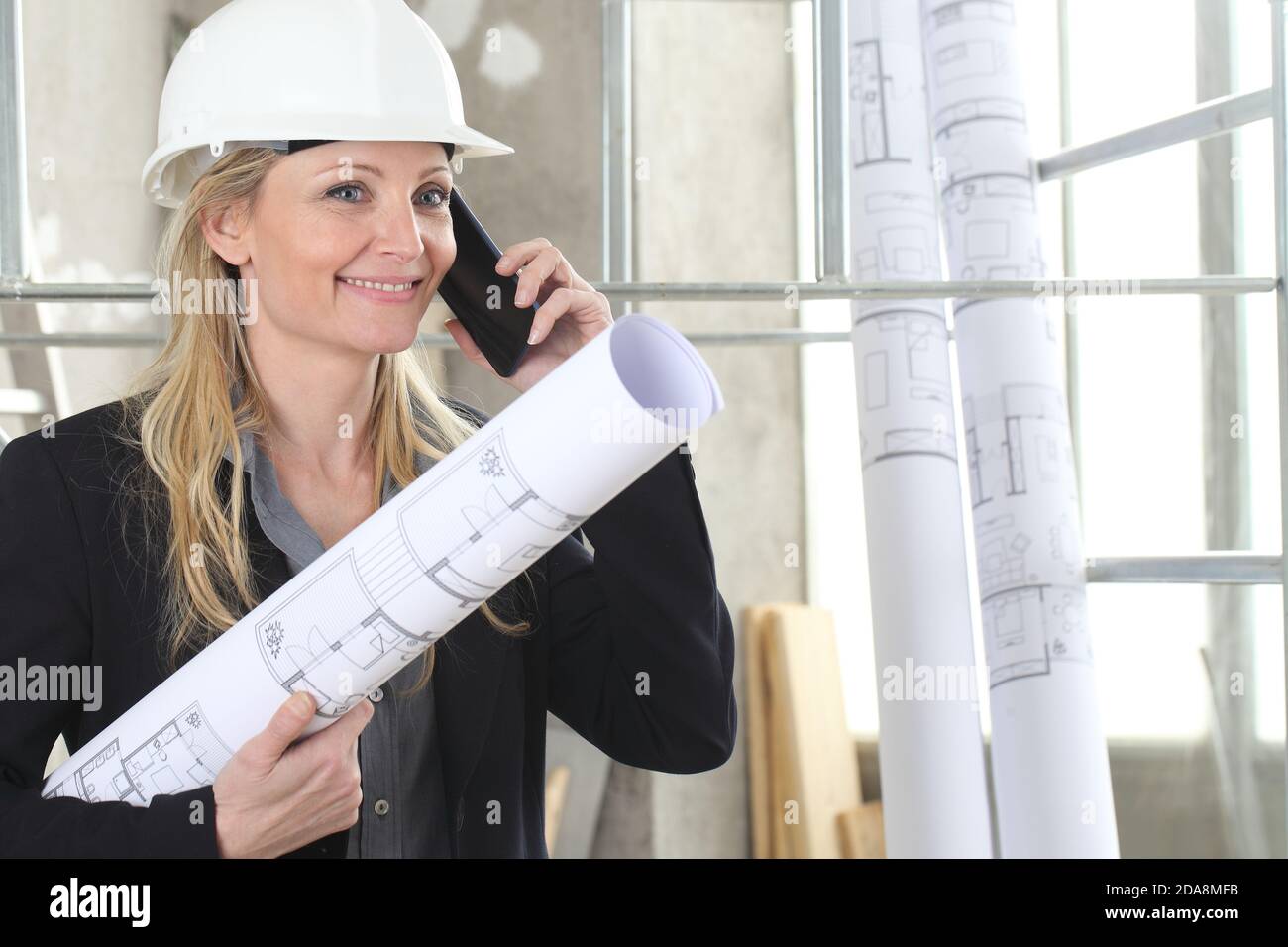 smiling woman architect or construction engineer talk on the mobile ...