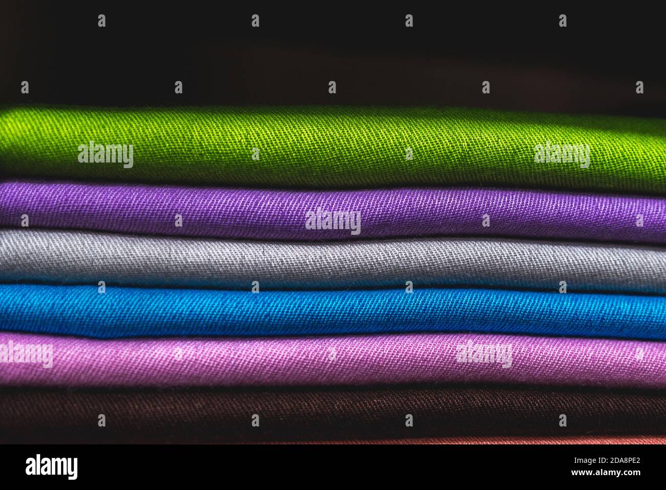 Green purple grey blue pink brown pile of textile, close up of colorful ...