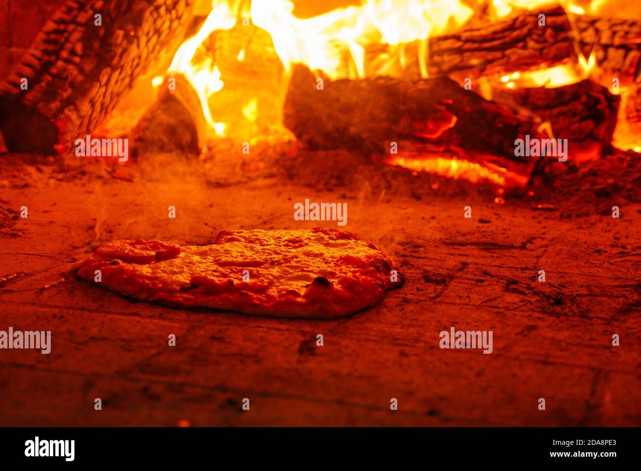 Bread cooking on floor of burning stone hearth. Close up Stock Photo ...