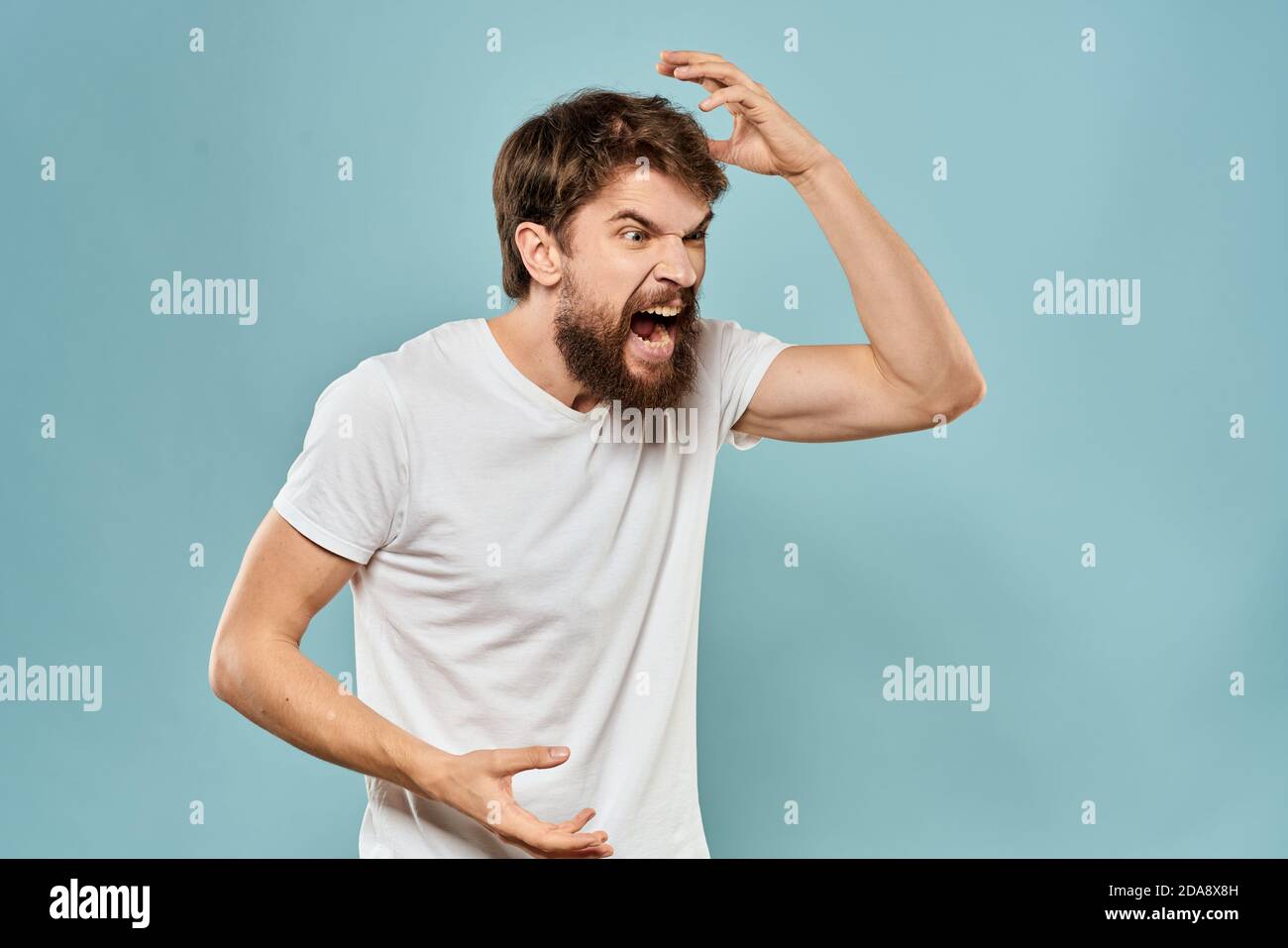 Man gestures with his hands emotions displeasure white t-shirt blue ...