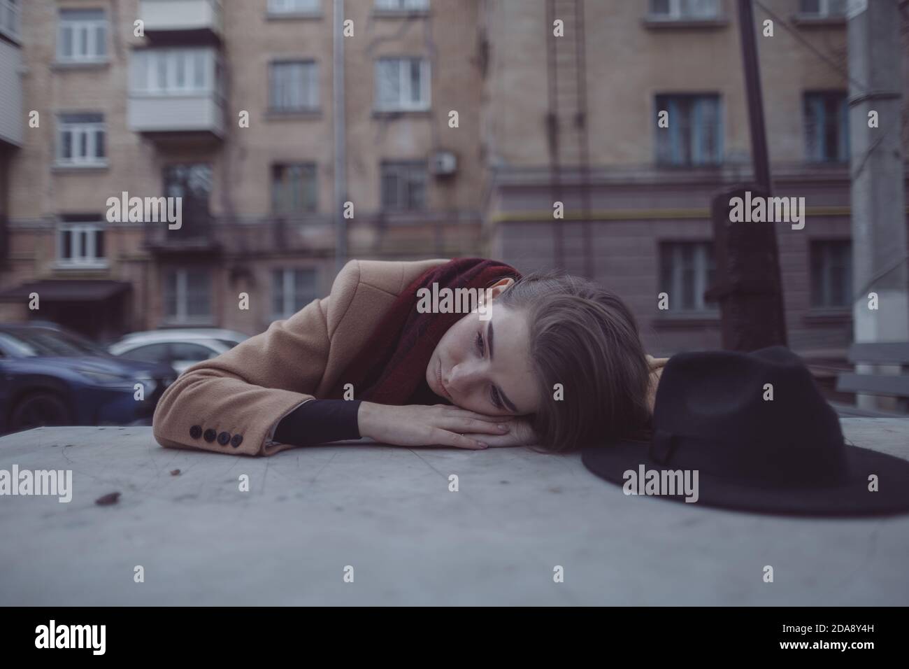 sad Ukrainian young girl sitting on a bench in the yard of his ...