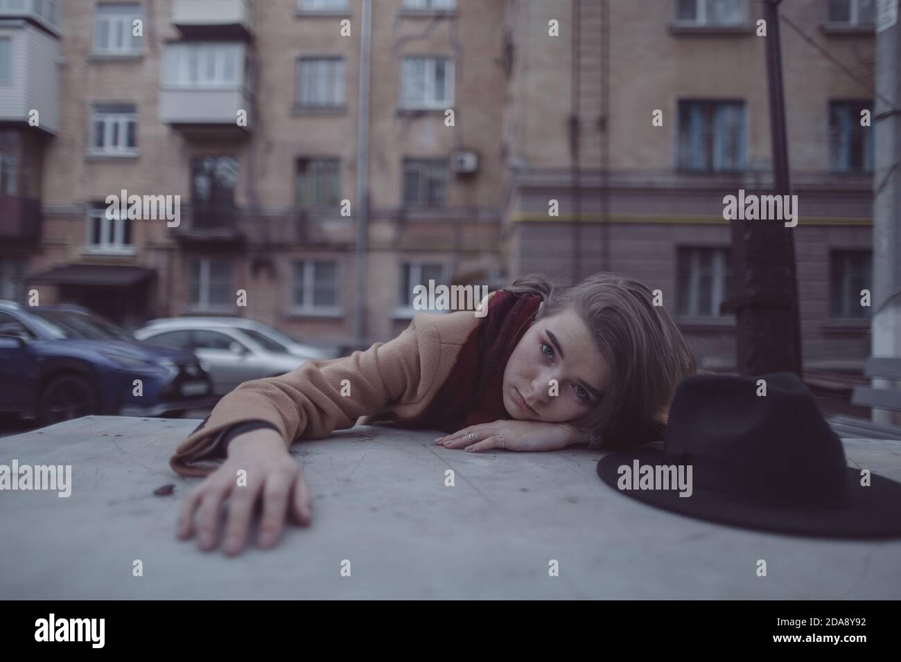 sad Ukrainian young girl sitting on a bench in the yard of his ...