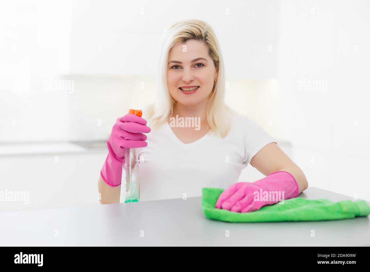 Woman cleaning dust from bookshelf. Young girl sweeping shelf, spring ...