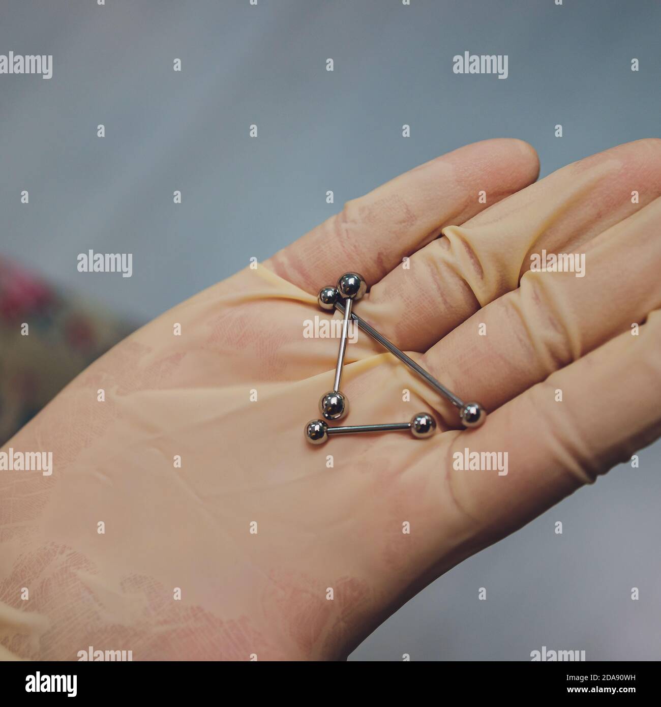 ear jewelry, piercing in hand with a disposable glove Stock Photo - Alamy