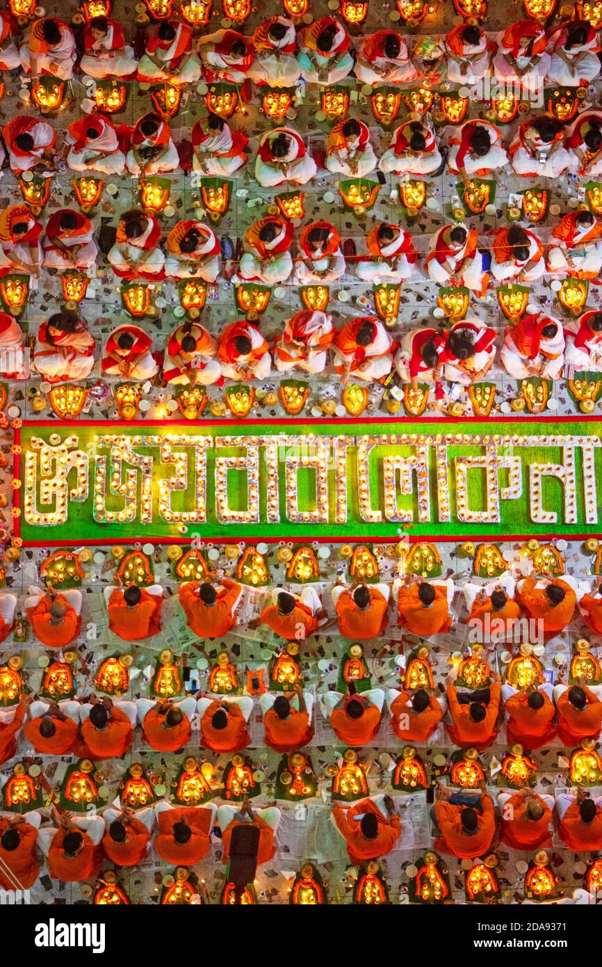 Bangladesh. 10th Nov, 2020. Hindu devotees sit with Prodip (lights) and ...