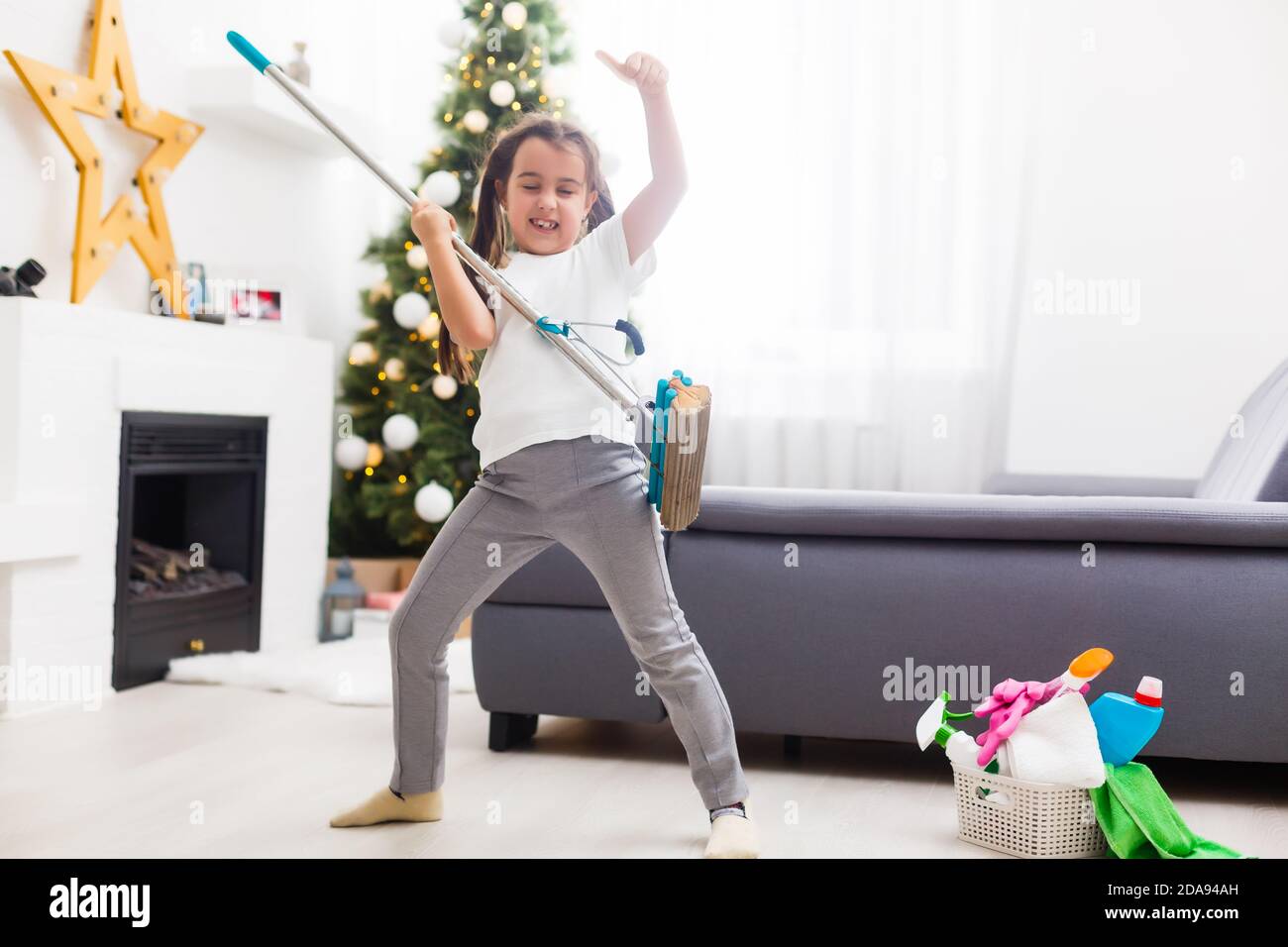 little girl cleaning after christmas on the background of Christmas ...