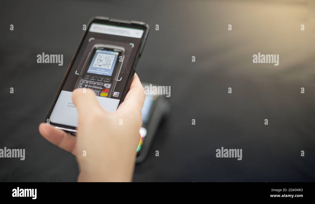 Female hand scanning the QR code with mobile phone for pay at the shop ...