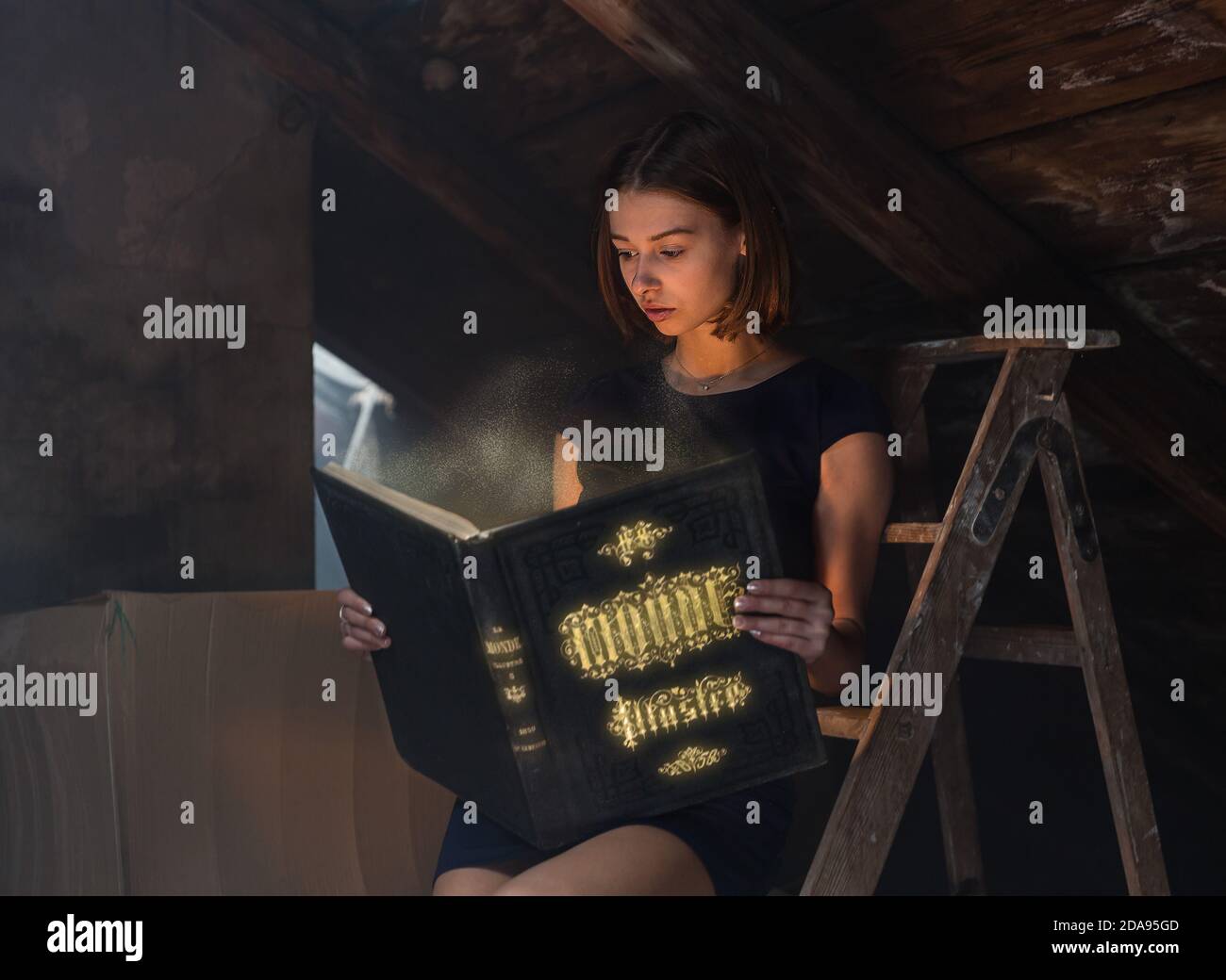 Attractive girl in black dress reading mystical book in attic Stock ...