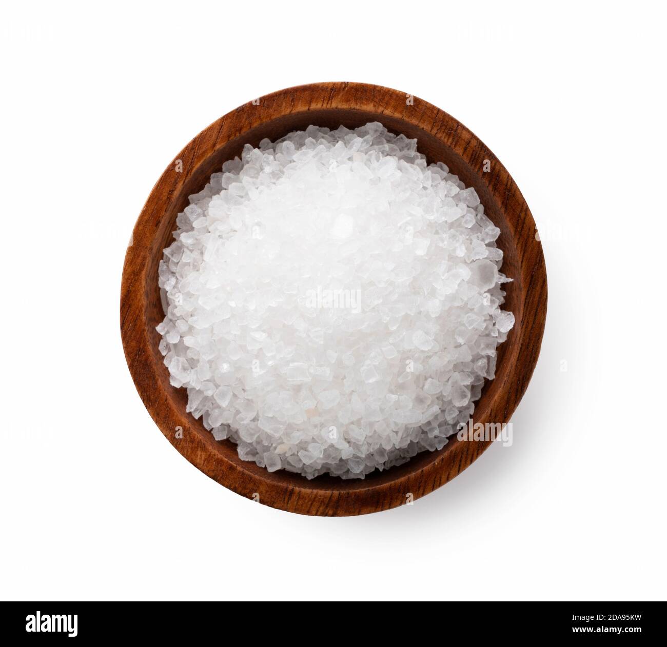 Himalayan rock salt in a wooden bowl placed on a white background. A ...