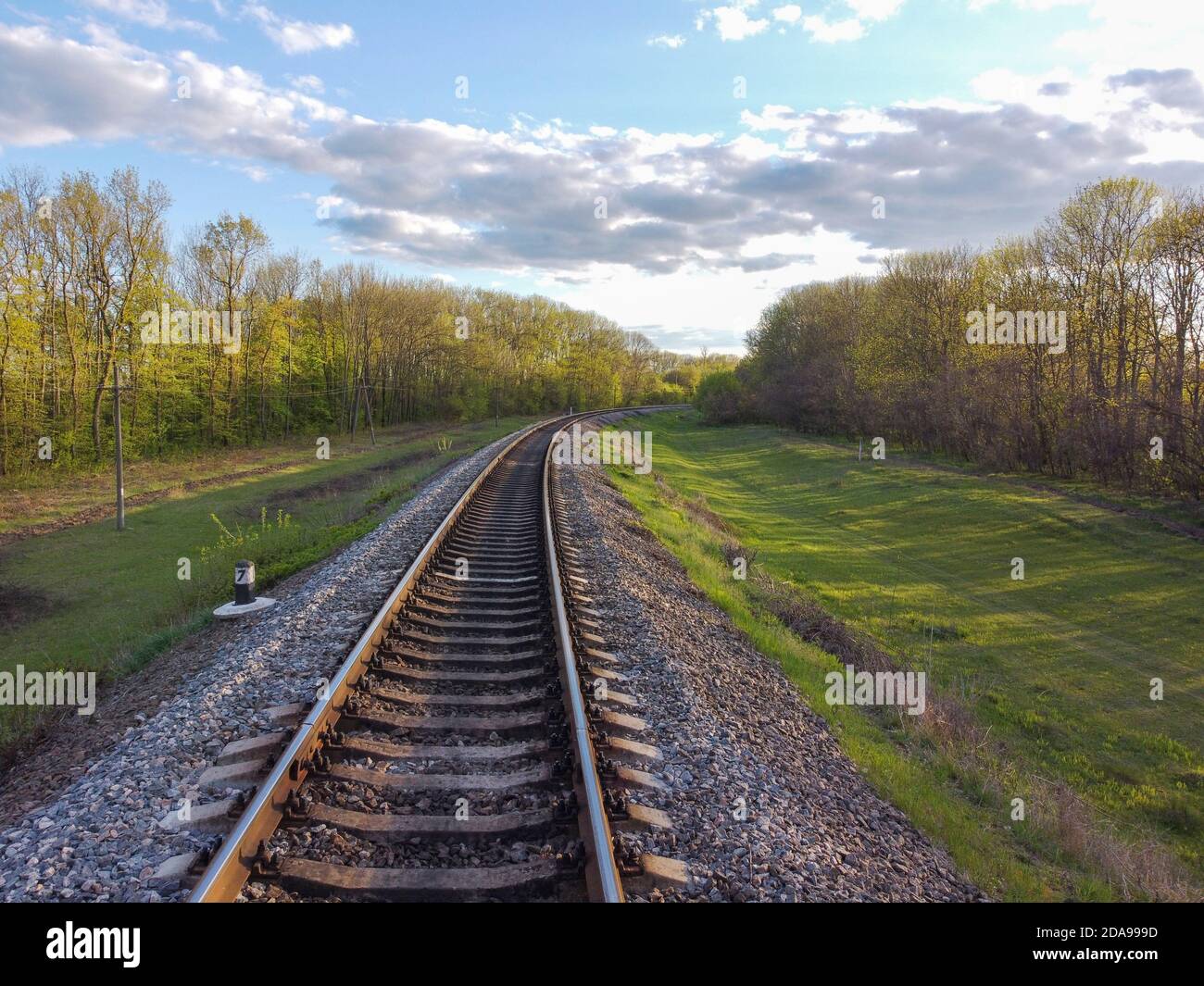 Railway, tracks through tree planting, green grass and beautiful nature ...