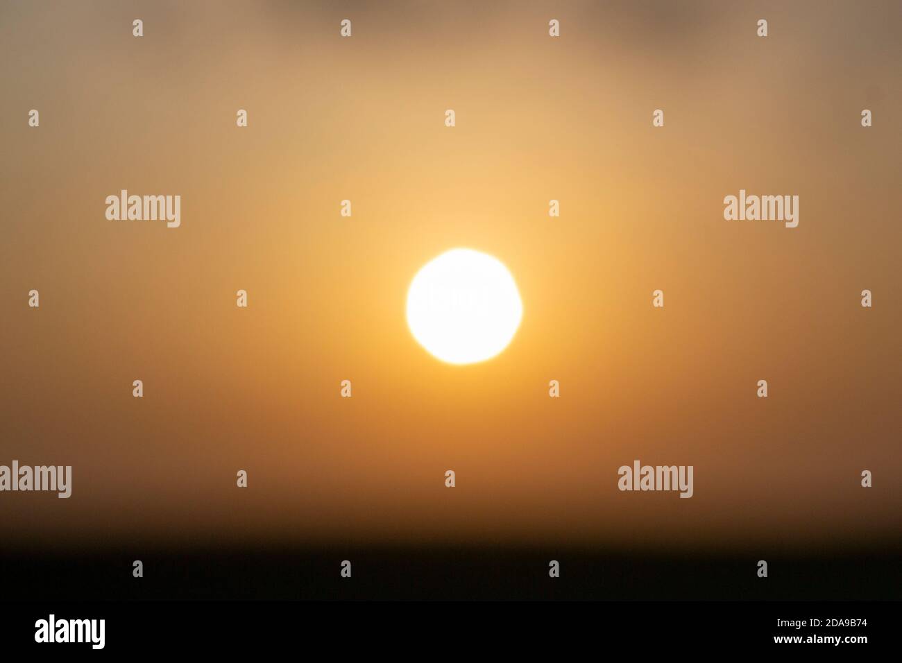 Blurry evening sun in the sky with sunset Stock Photo - Alamy