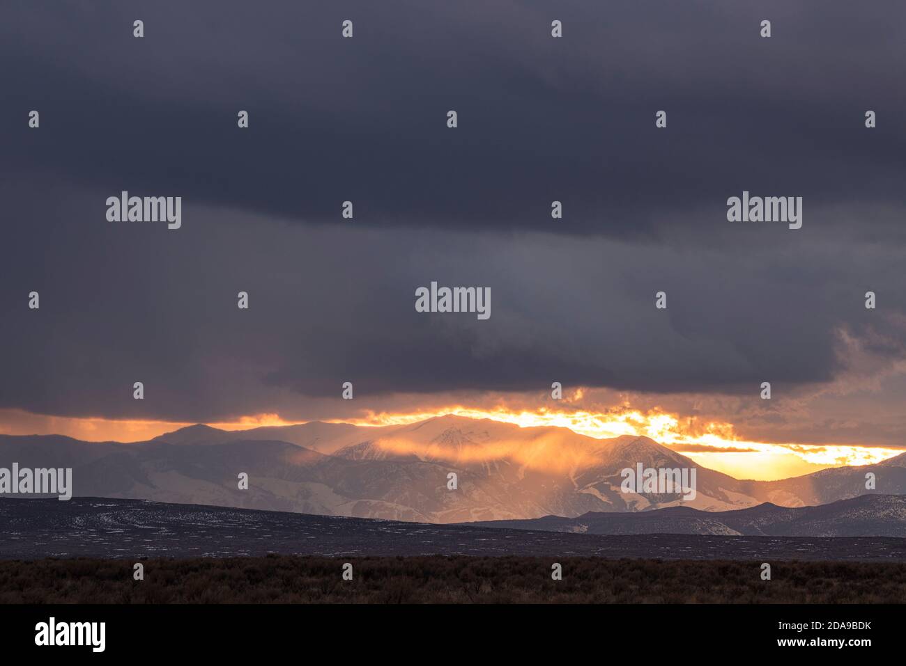 The sun shines through spring storm clouds as it sets on the southern ...