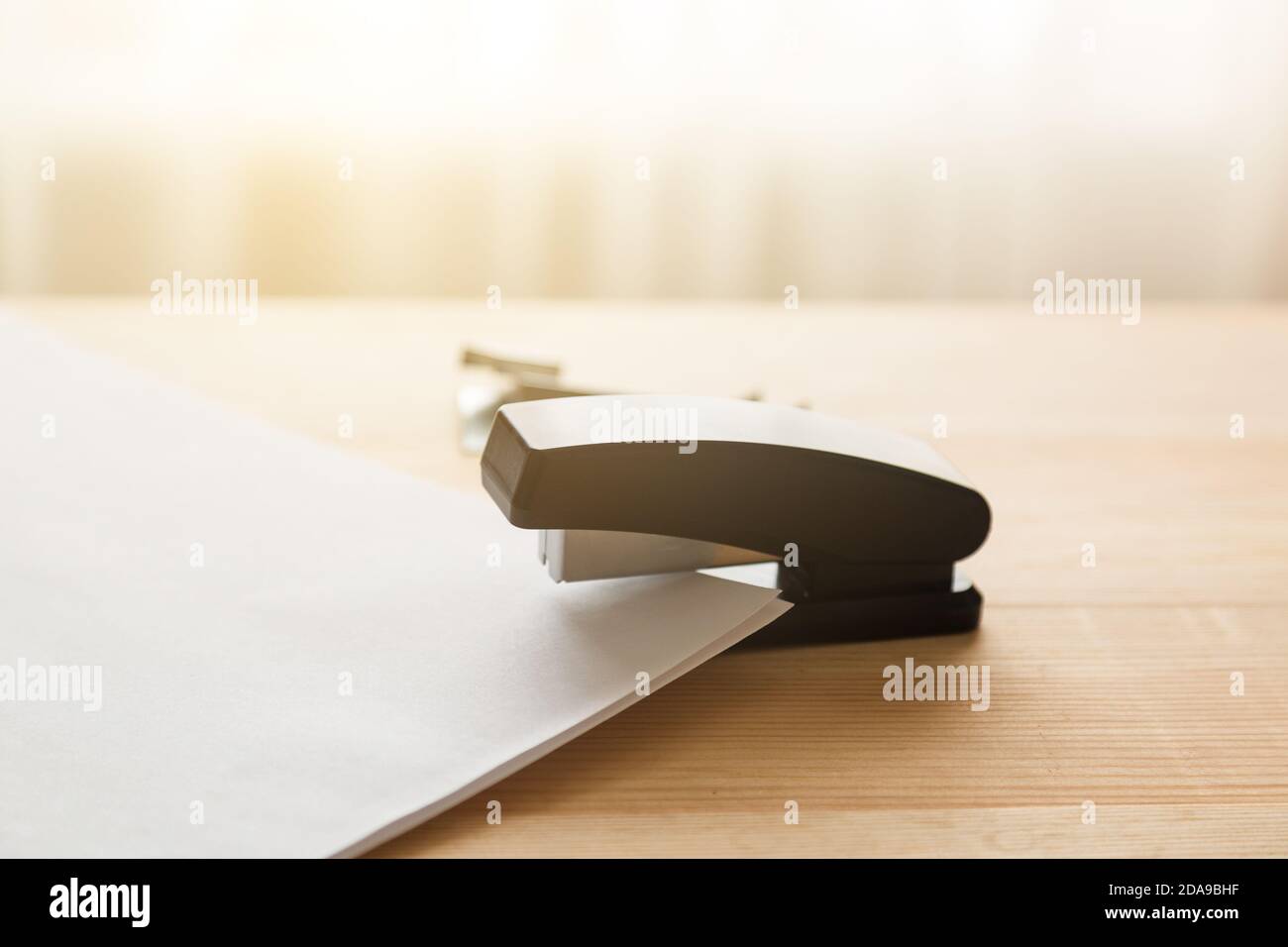 Stapler and staples with sheets of paper on wooden table Stock Photo ...