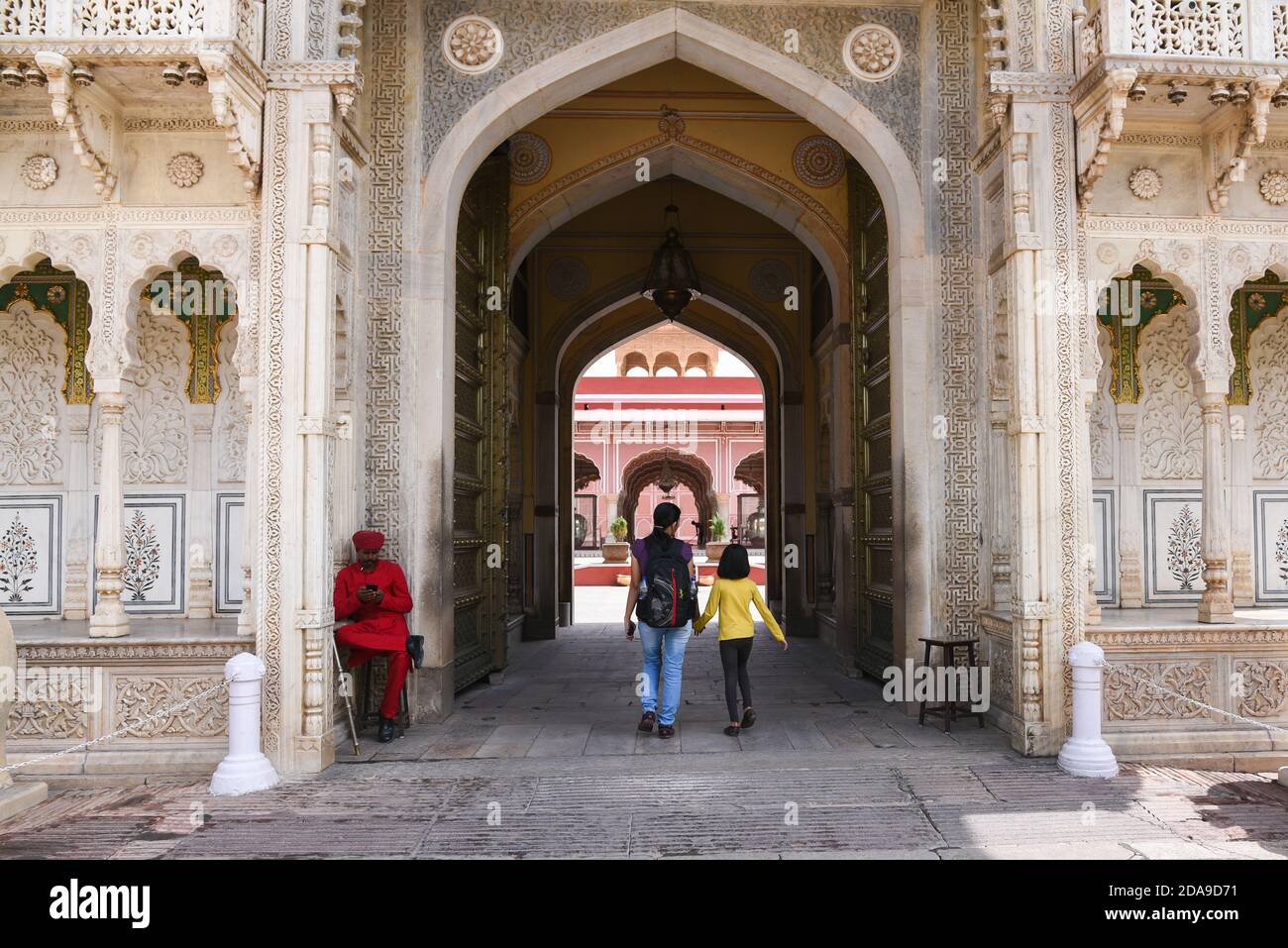 Woman tourist at Ganesh Pol gateway decorated entrance to City Palace ...