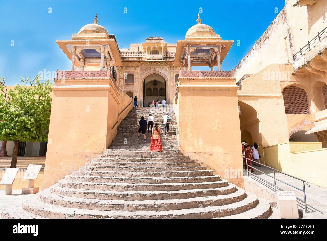Woman tourist at Ganesh Pol gateway decorated entrance to Amber Palace ...