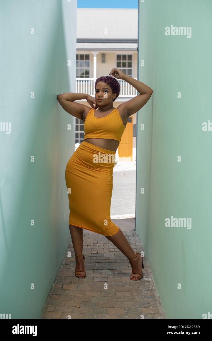 Young woman with colorful hair standing in a alley Stock Photo - Alamy