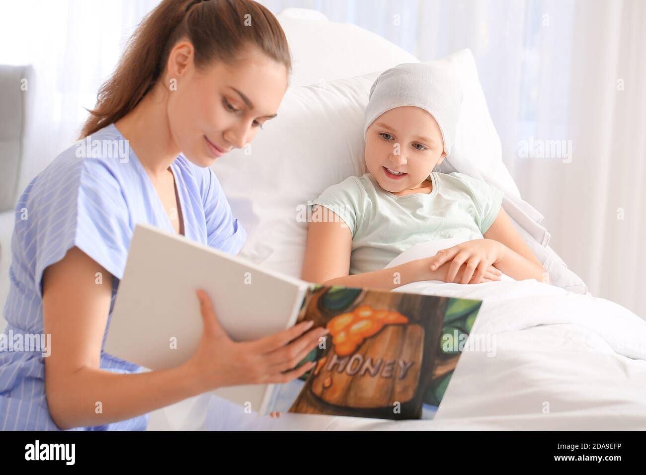 Woman reading book to her daughter who is undergoing course of ...