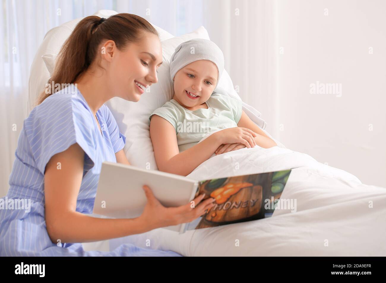 Woman reading book to her daughter who is undergoing course of ...