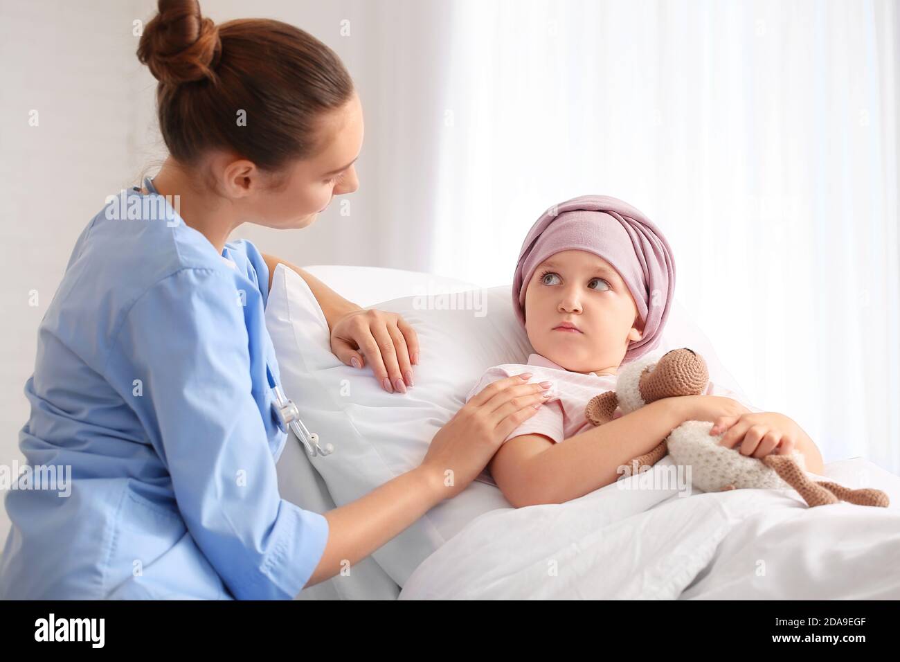 Nurse and little girl undergoing course of chemotherapy in clinic Stock ...