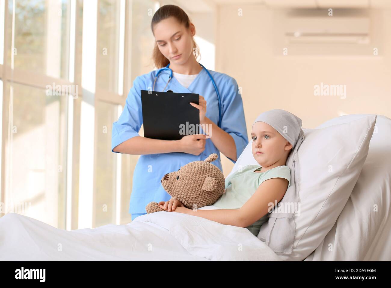 Nurse and little girl undergoing course of chemotherapy in clinic Stock ...