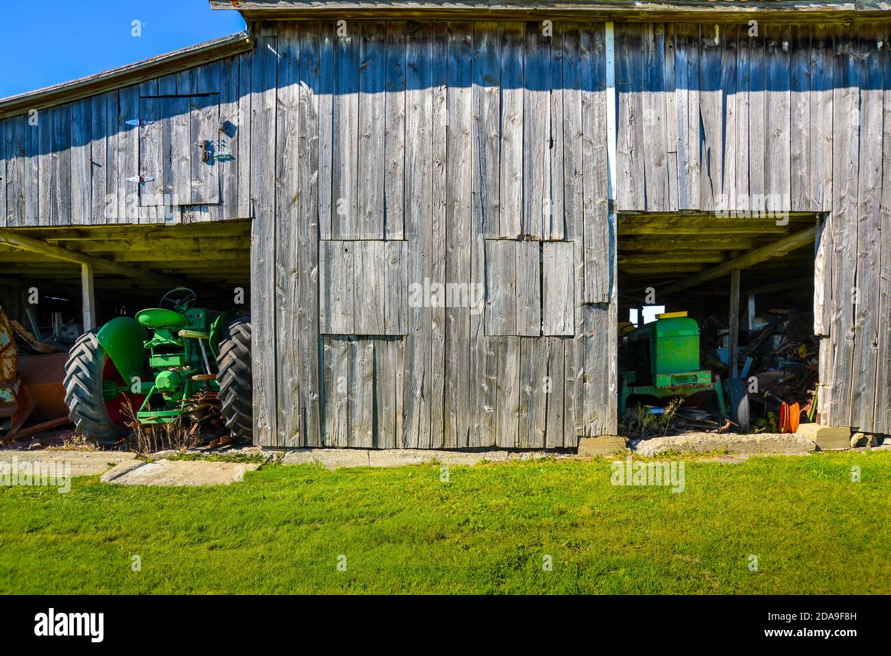 Old wooden grey plank barn for storing tractors and farm equipment ...