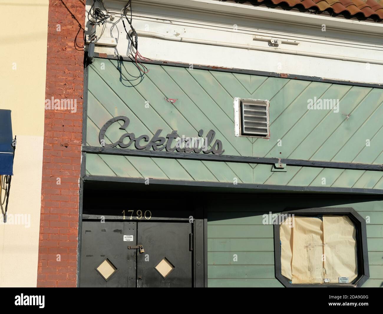 Cocktails sign in cursive script over a closed bar that is no longer ...